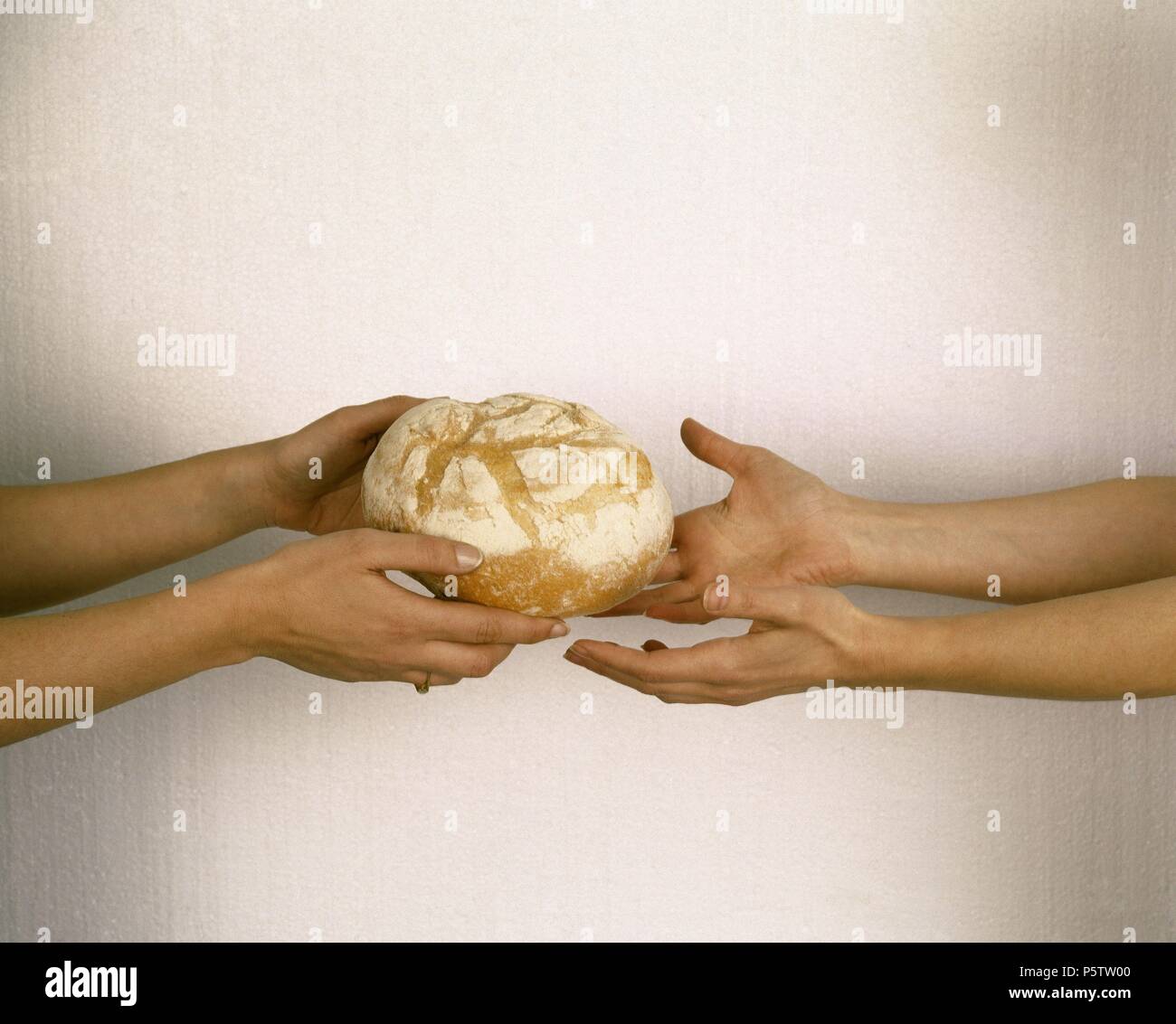 DOS MANOS.UNA RECIBIENDO Y OTRA OFRECIENDO PAN Stock Photo - Alamy