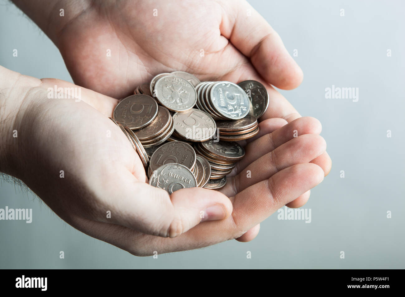 Coins falling in hands hi-res stock photography and images - Alamy