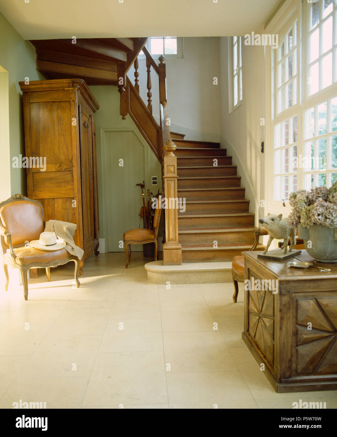 Antique chair and carved woooden chest in French country hall with ...