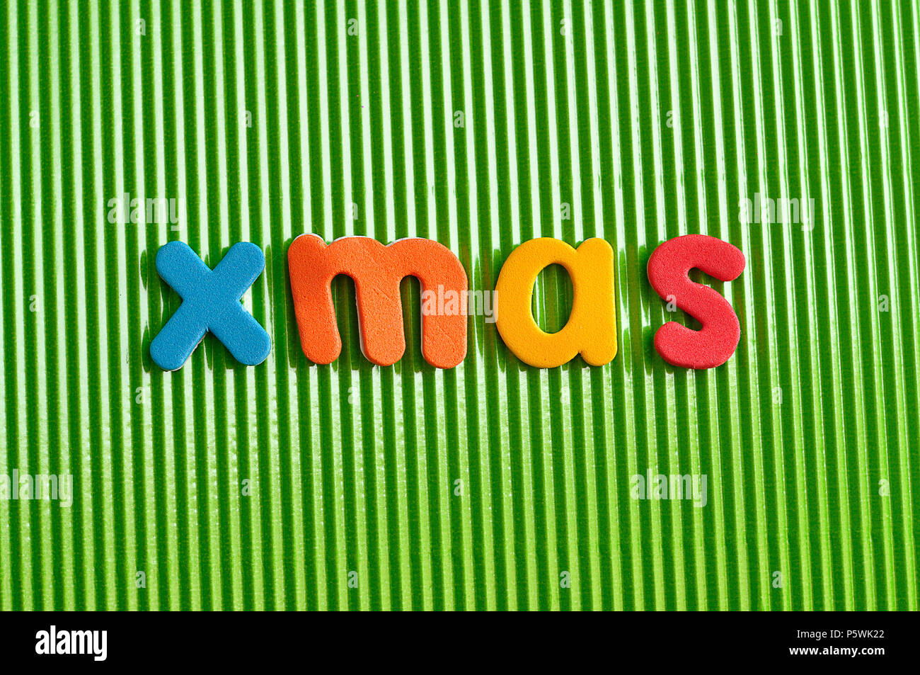 The word Xmas in colorful letters on a green background Stock Photo - Alamy
