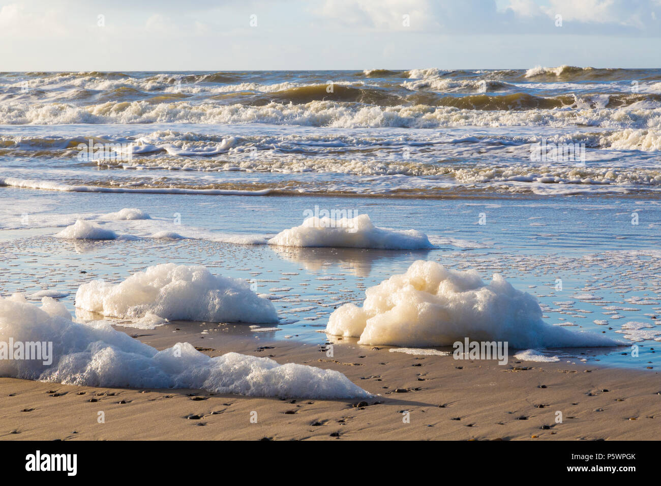 After storm in the North Sea. Sea foam on the beach in Hvide Sande ...