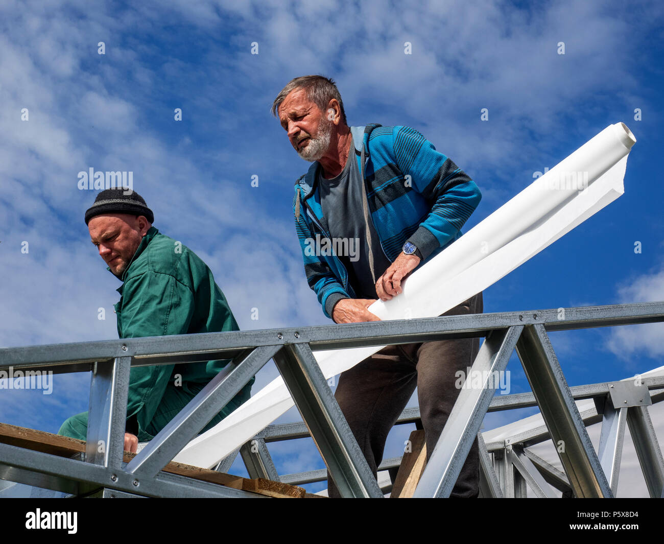 Caucasian men performs roofing work. Installation of moisture barrier ...