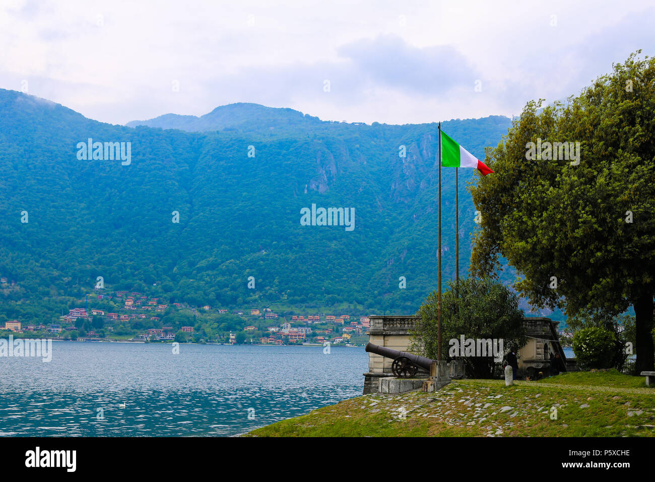 Italian flag and gun with Alps in background, lake Como in Mandello del ...