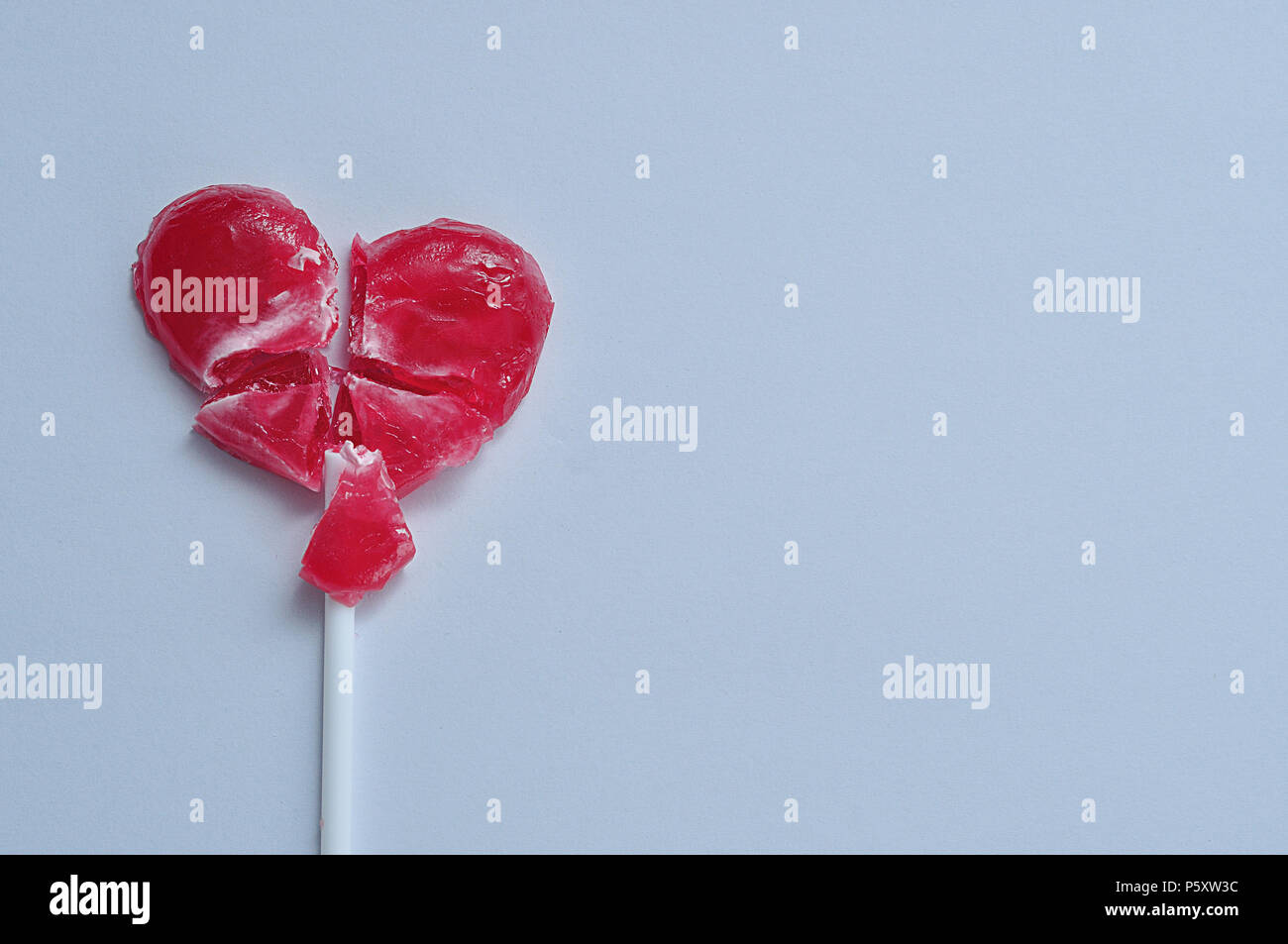 A broken red heart lollipop symbolizing a broken heart Stock Photo - Alamy