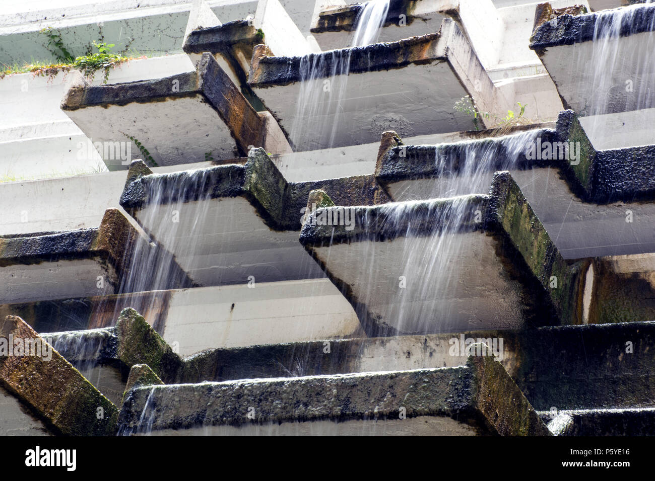 Man made artificial abandoned waterfalls in spa. Old and green ditch ...