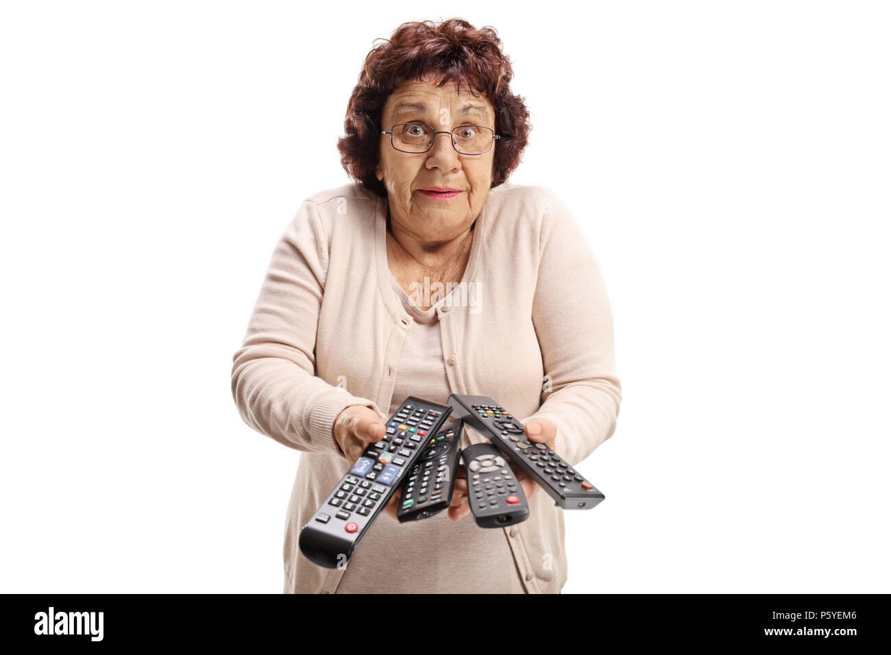 Confused elderly woman with remote controls isolated on white ...