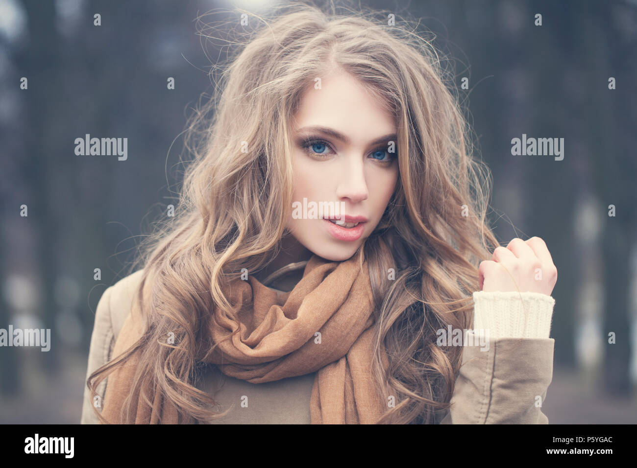 Beautiful young female model outdoors in park. Woman with long curly ...