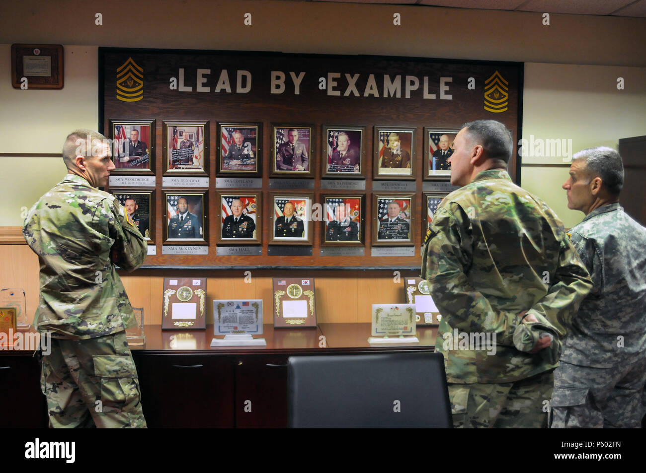 Sergeant Major of the Army Daniel Dailey (far left) views a photo board ...