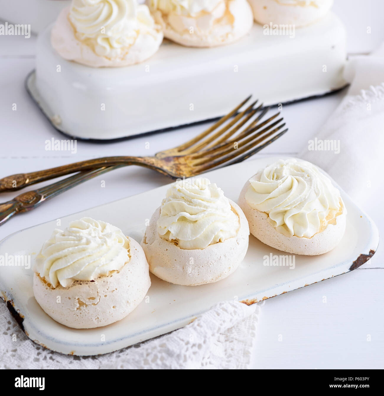 baked round puff pastry with cream on an iron plate and two forks Stock ...