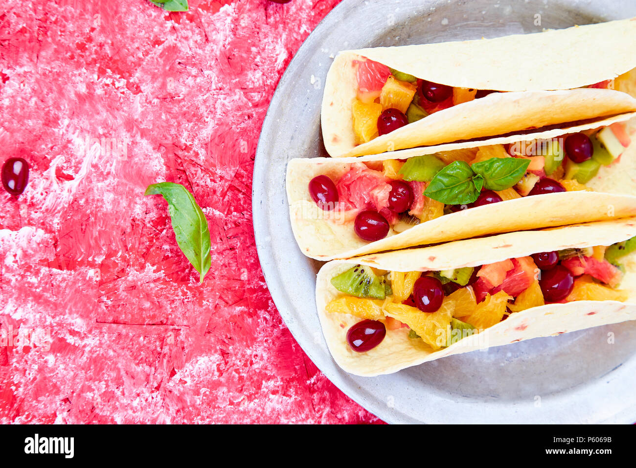 Fruit tacos with orange, kiwi, grapefruit red background and berry ...