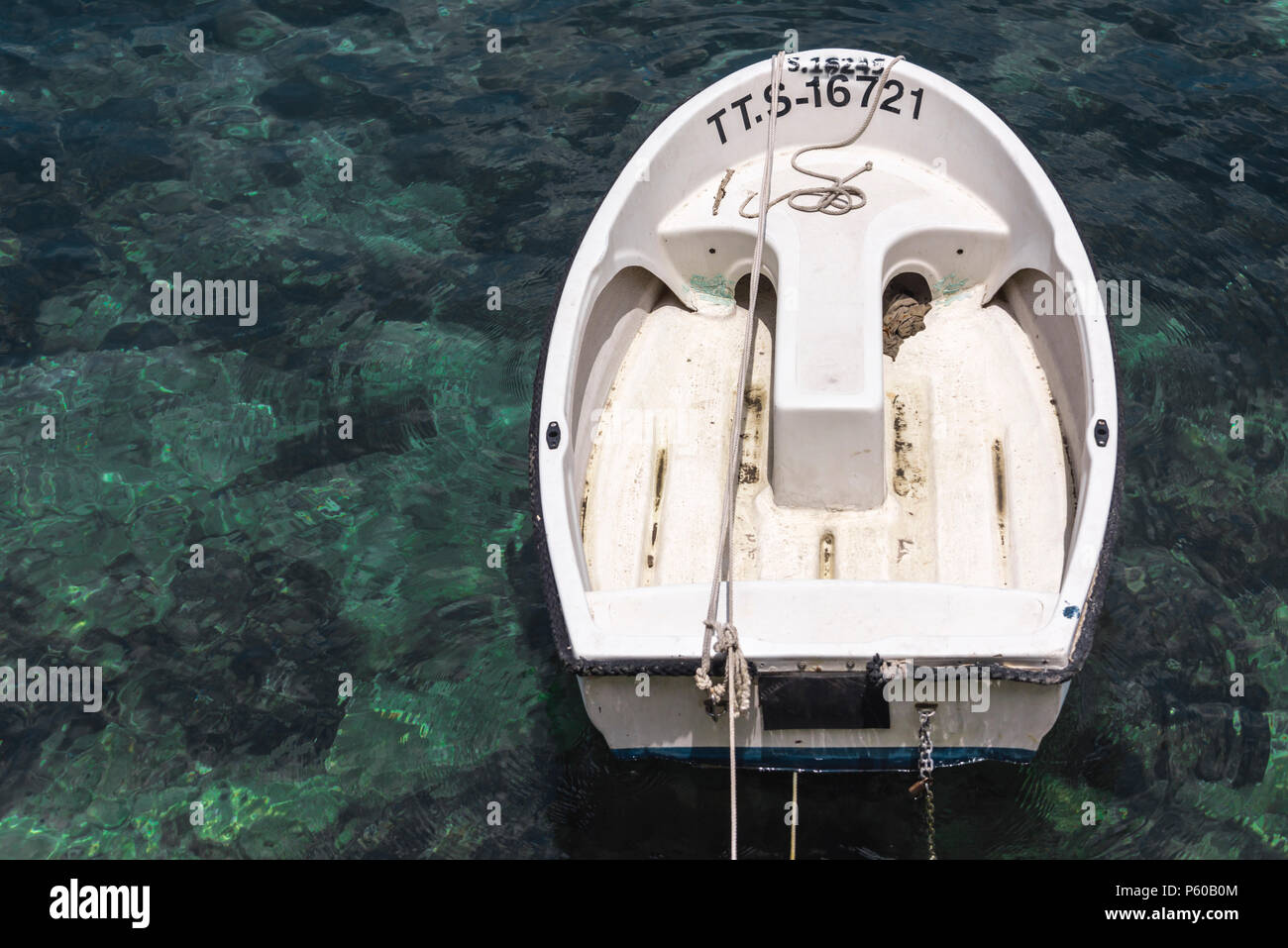 Small fibreglass rowing boat tied up in a shallow harbour Stock Photo ...