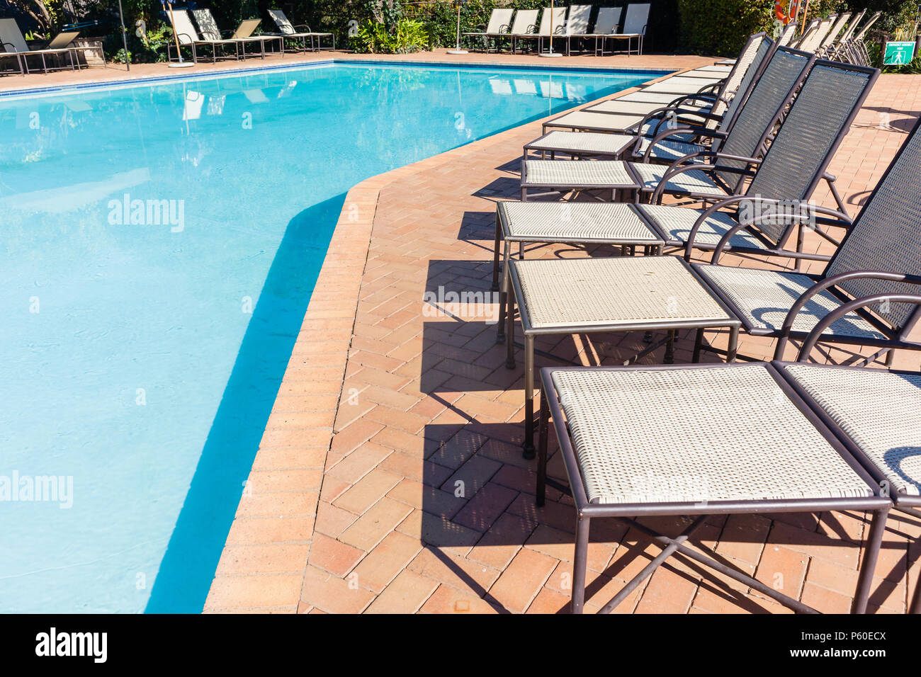 Swimming pool with dozen public benches chairs at scenic outdoors venue ...