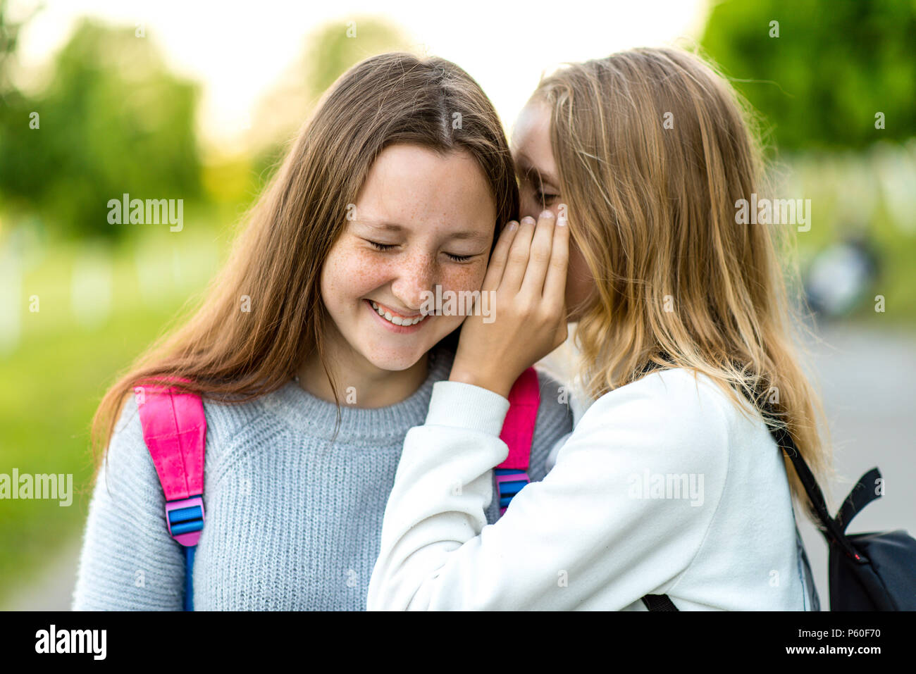 Two girl friends schoolgirls teenagers. In summer city park. Concept of ...