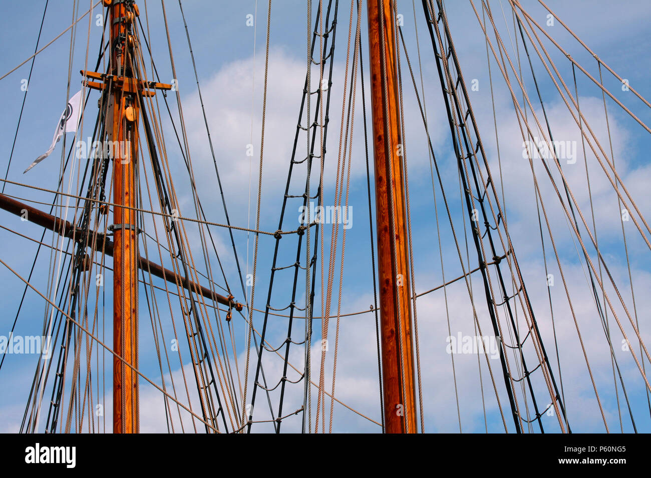 Rigging of a tall wooden ship in a port in sunlight in summer with blue ...