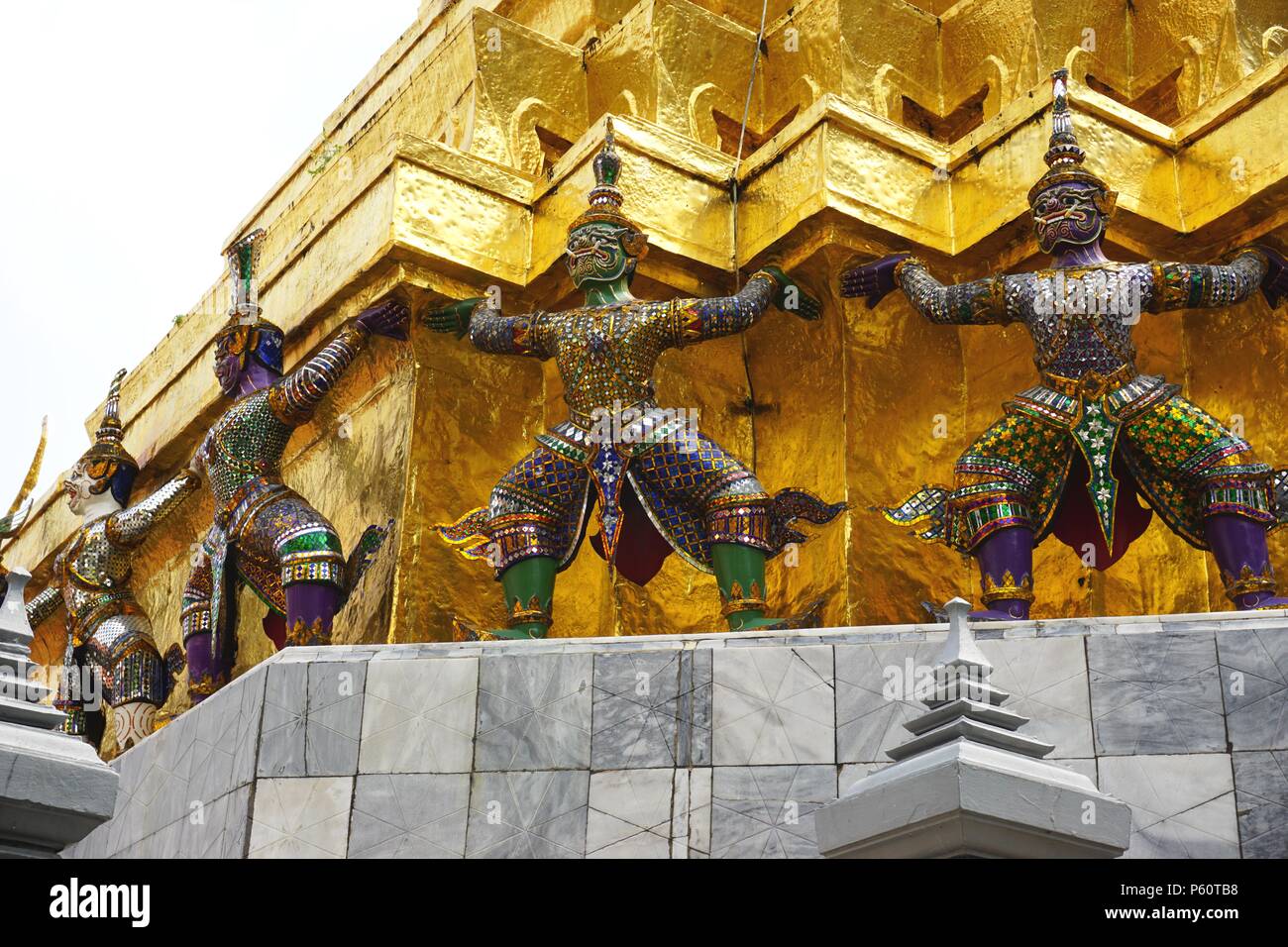 Colorful Garuda figures with outstretched arms and legs support a huge ...