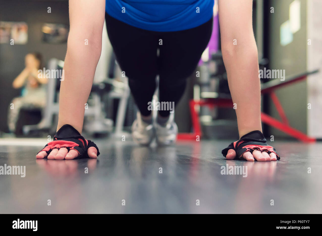 Close up hand of woman doing push ups in the gym. Training girls in the ...