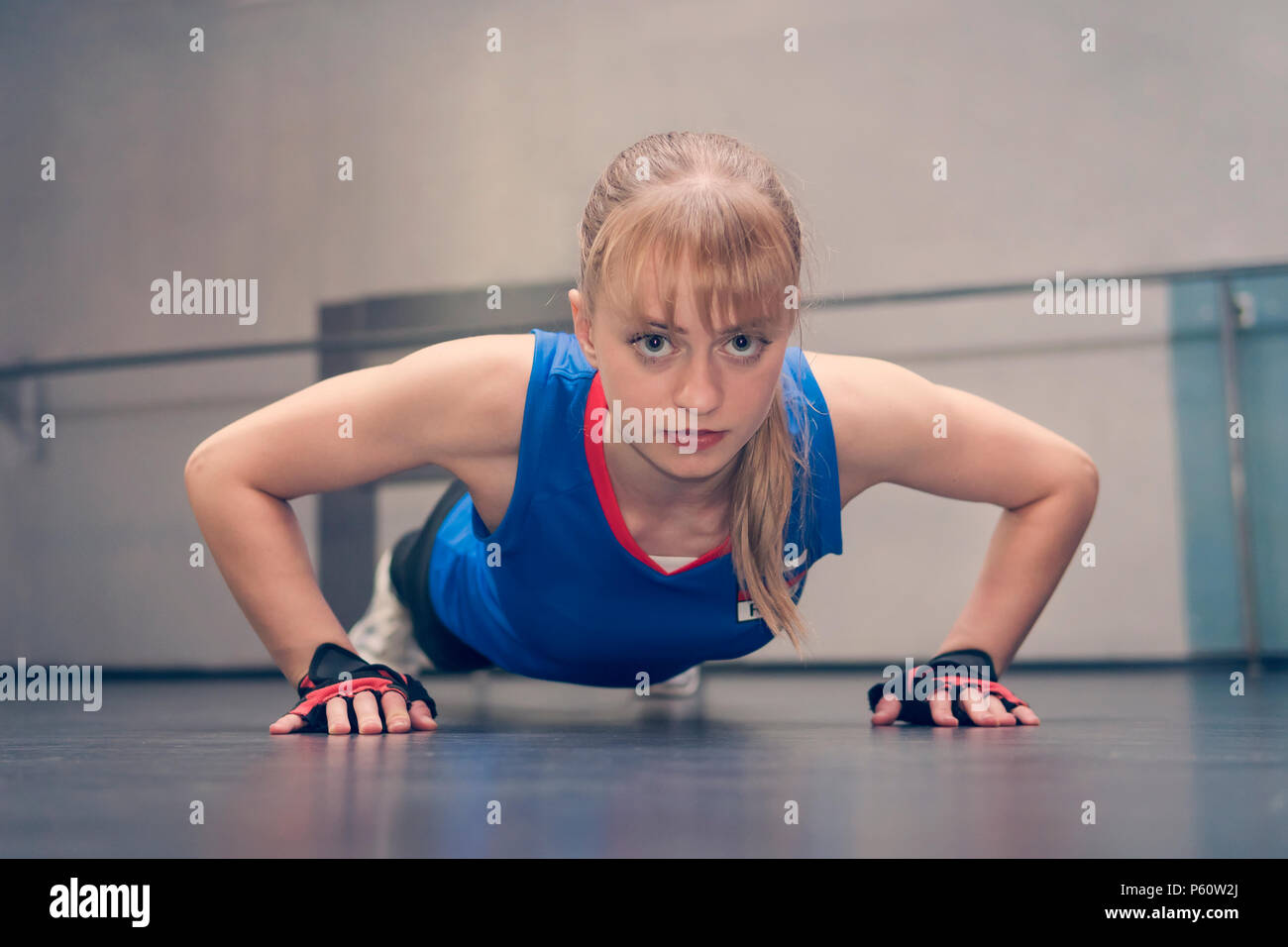 young fitness woman doing push ups. Athlete with white hair in the ...