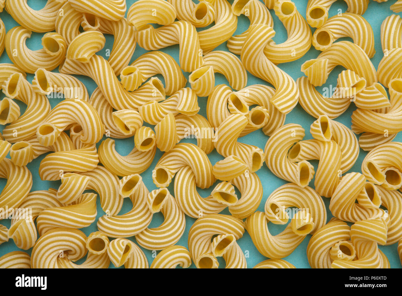ellow background of pasta in the form of tubes spun in a spiral Stock ...