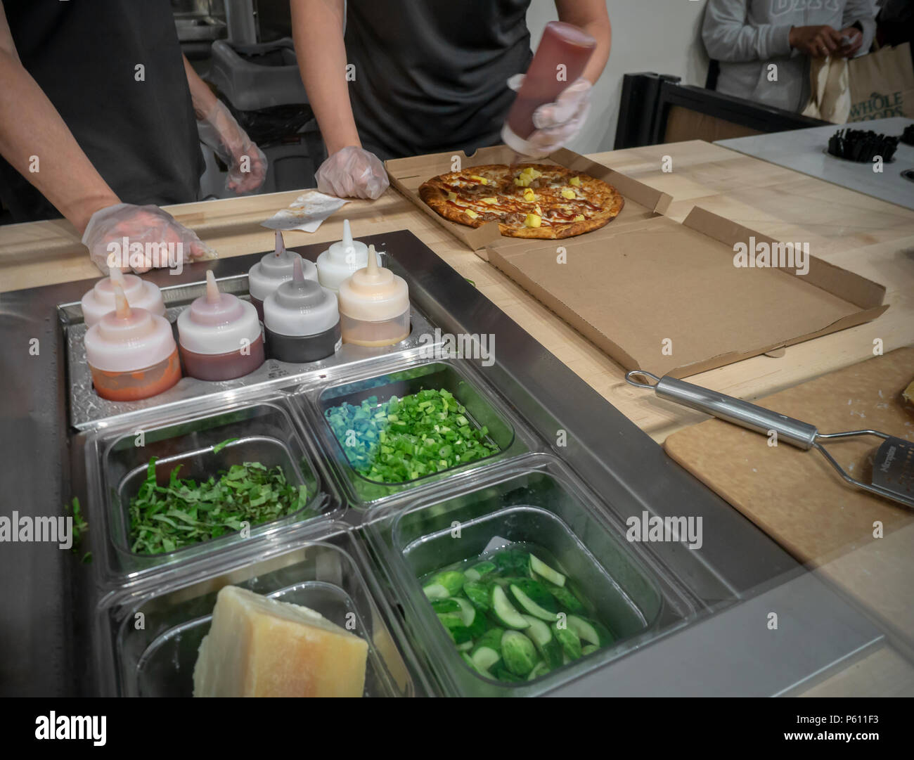 New York, USA, 27 June 2018. Employees construct a pizza right before ...