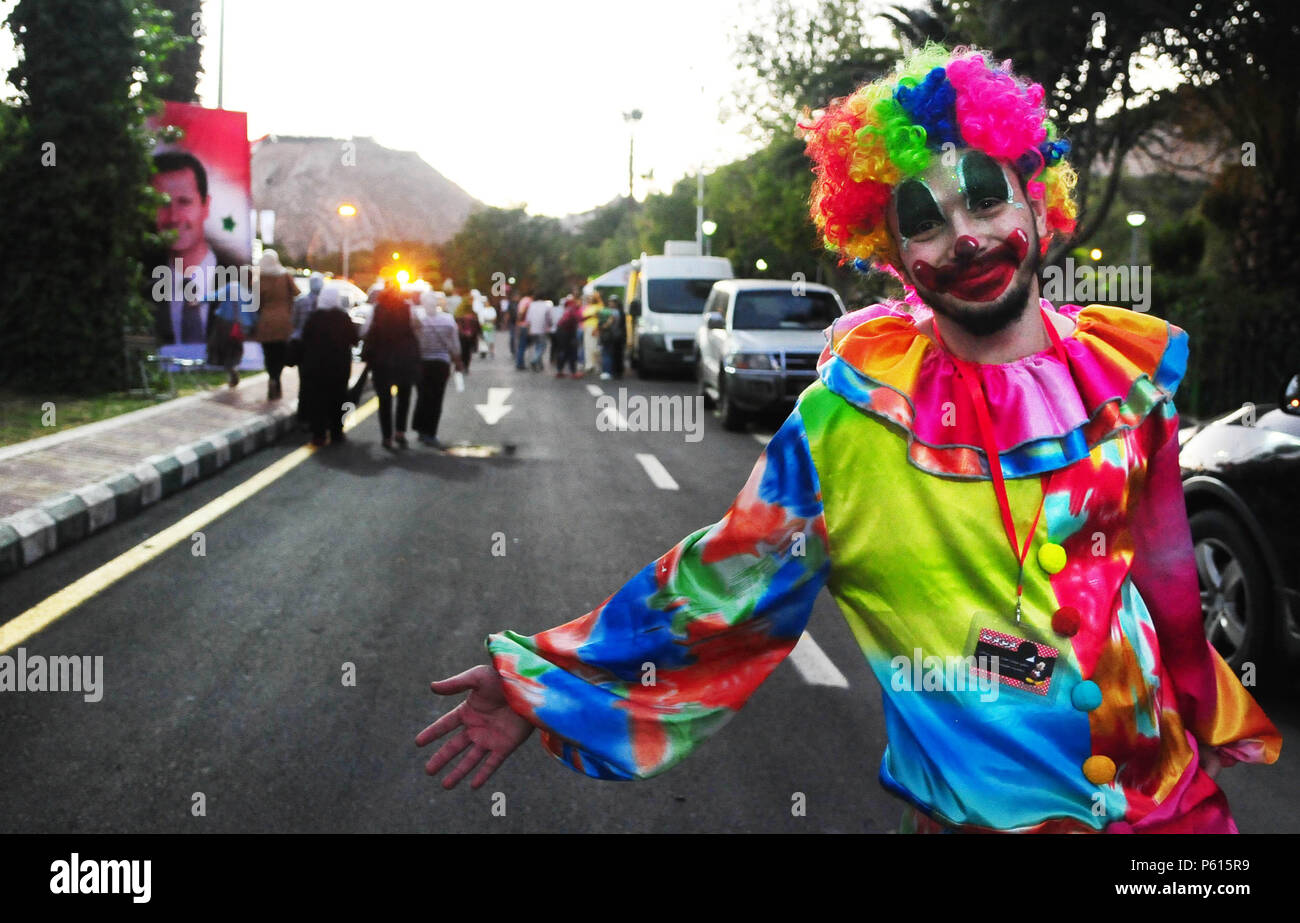 Damascus, Syria. 27th June, 2018. A clown welcomes people during a ...
