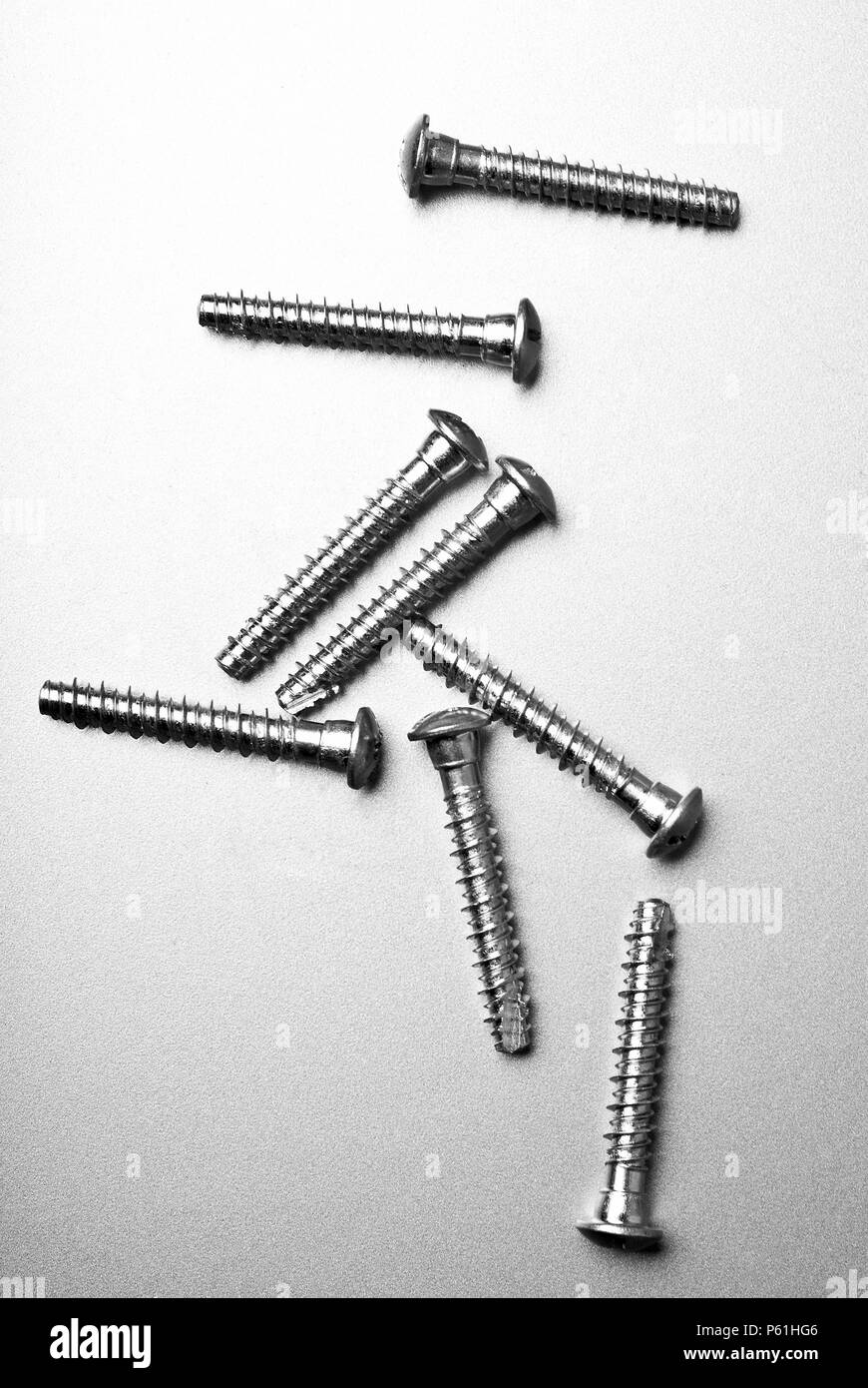 eight screws scattered on a metal surface Stock Photo - Alamy