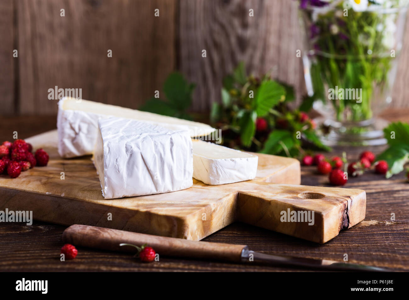 French brie cheese, wild strawberries and white purple wild flower ...