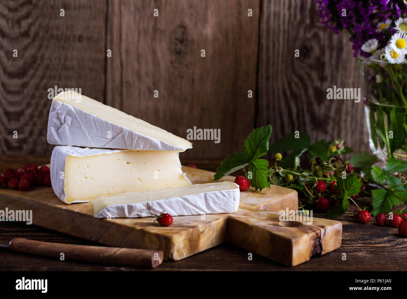 French brie cheese, wild strawberries and white purple wild flower ...