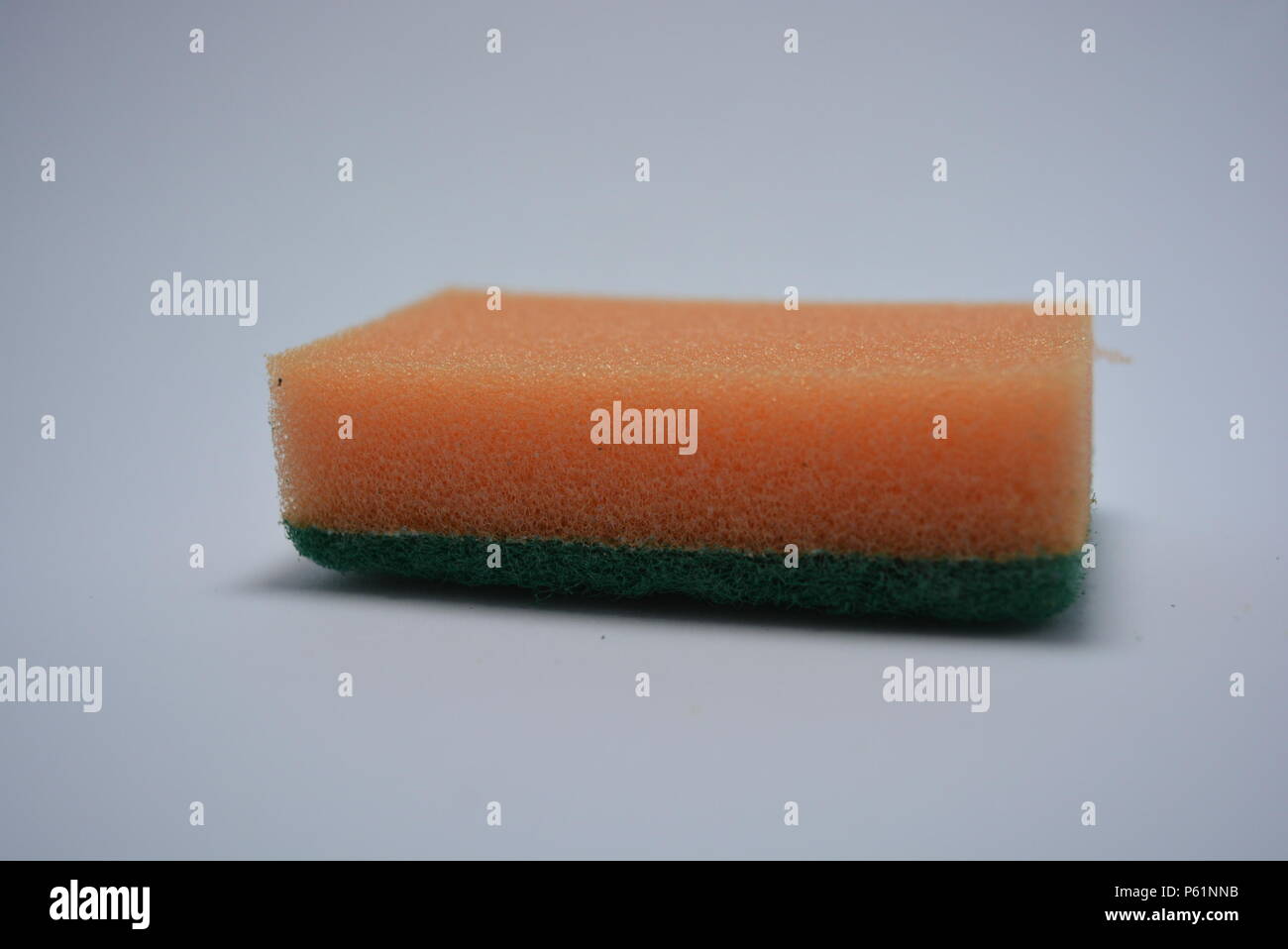 A new orange with a green sponge for washing glass and dishes on a ...