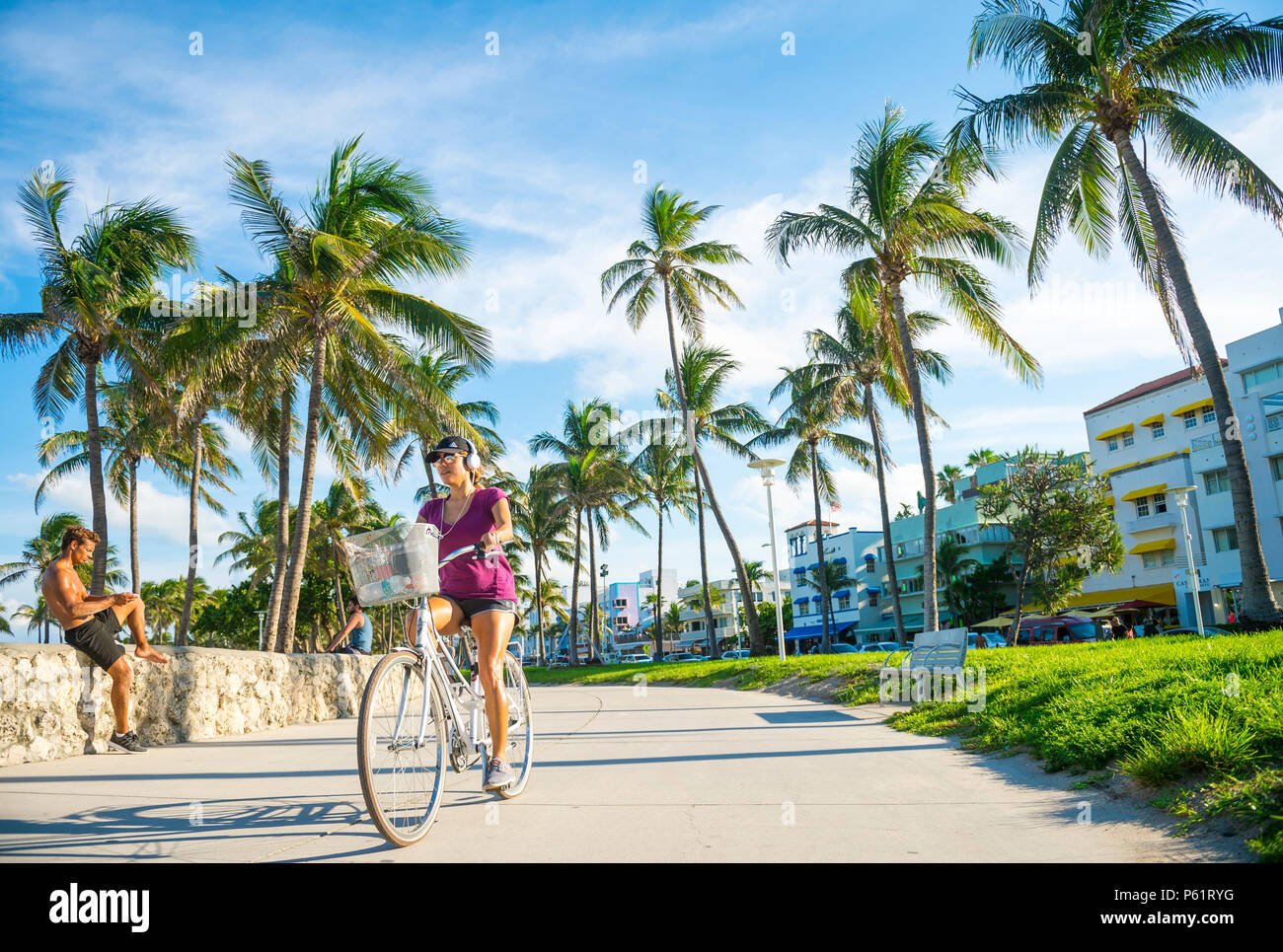 MIAMI - CIRCA JUNE 2017: Athletic young woman rides bike along the ...