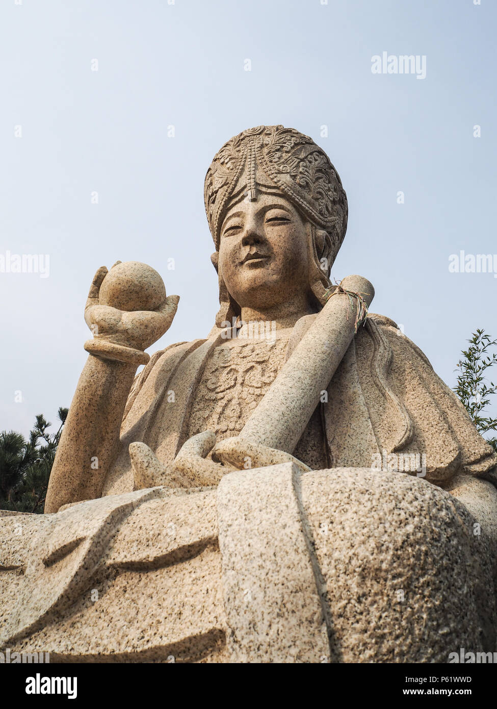 Qingdao, China - December 2017: white carved buddhist sculpture holding ...