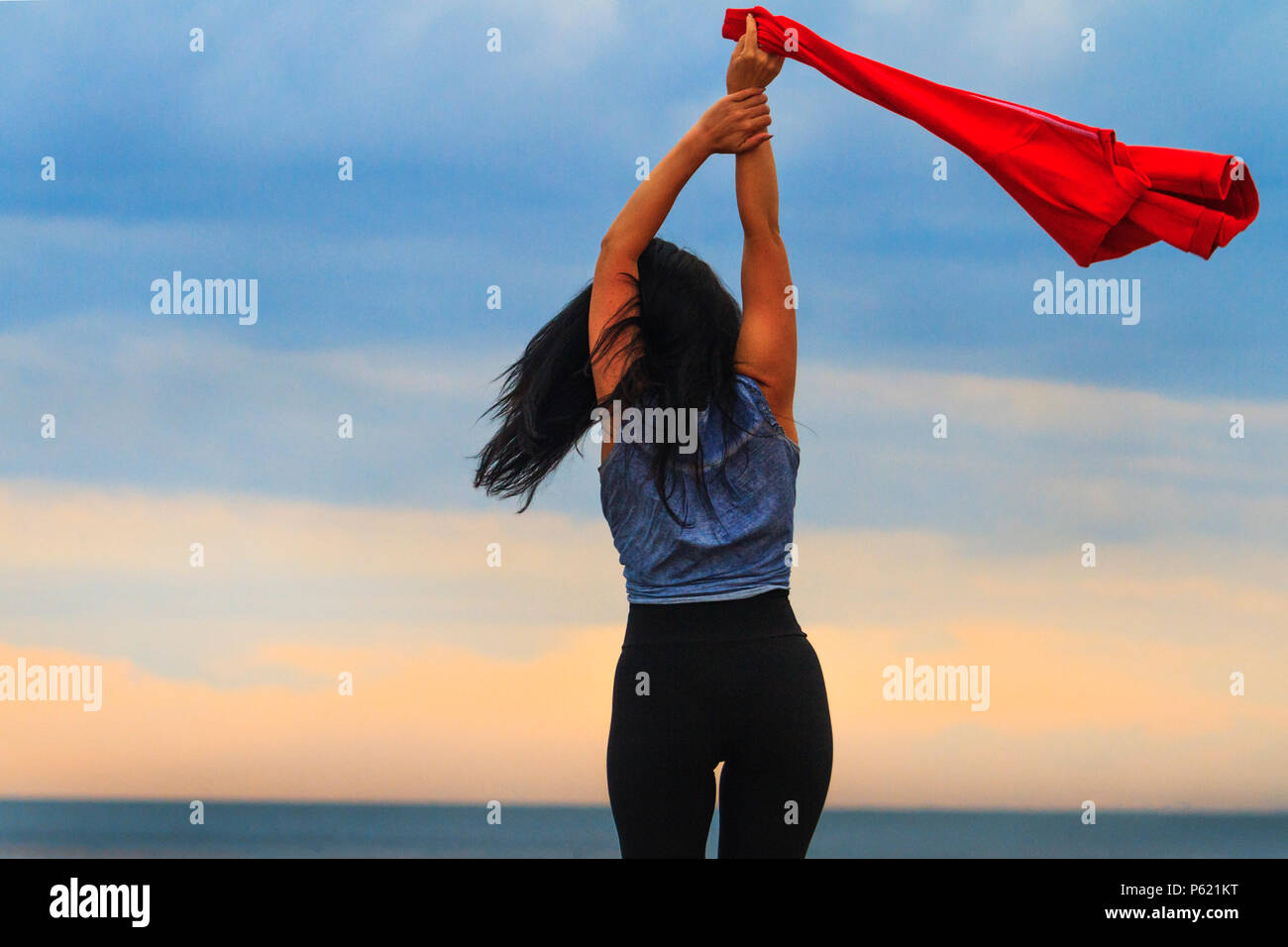 girl is rejoicing and waving a red flag Stock Photo - Alamy