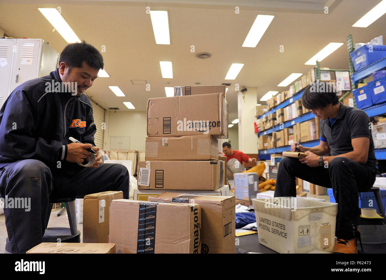 Japanese employees from the Kadena Post Office label a box number on a ...