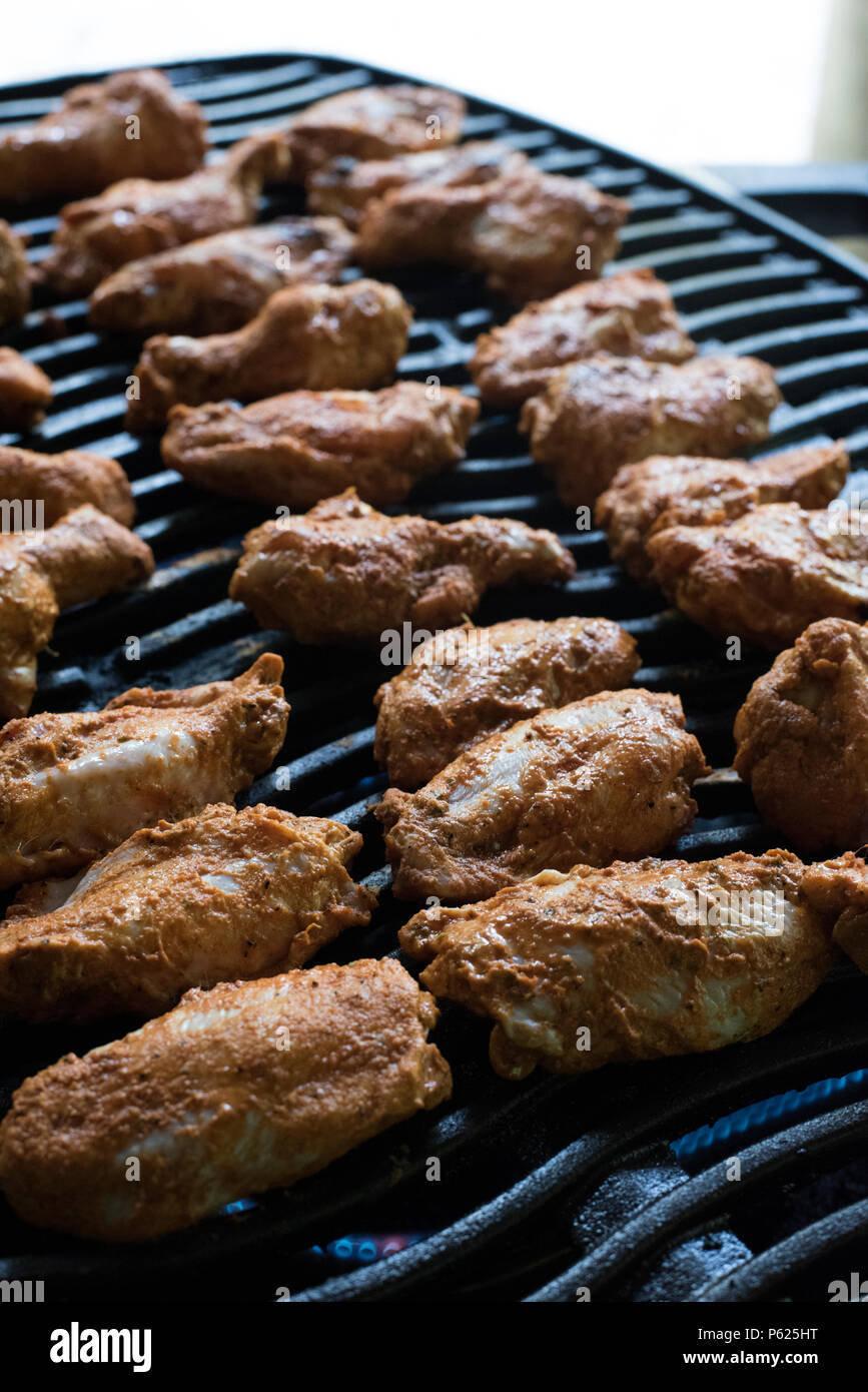 Barbecuing chicken wings and drumsticks on an outdoor grill Stock Photo ...