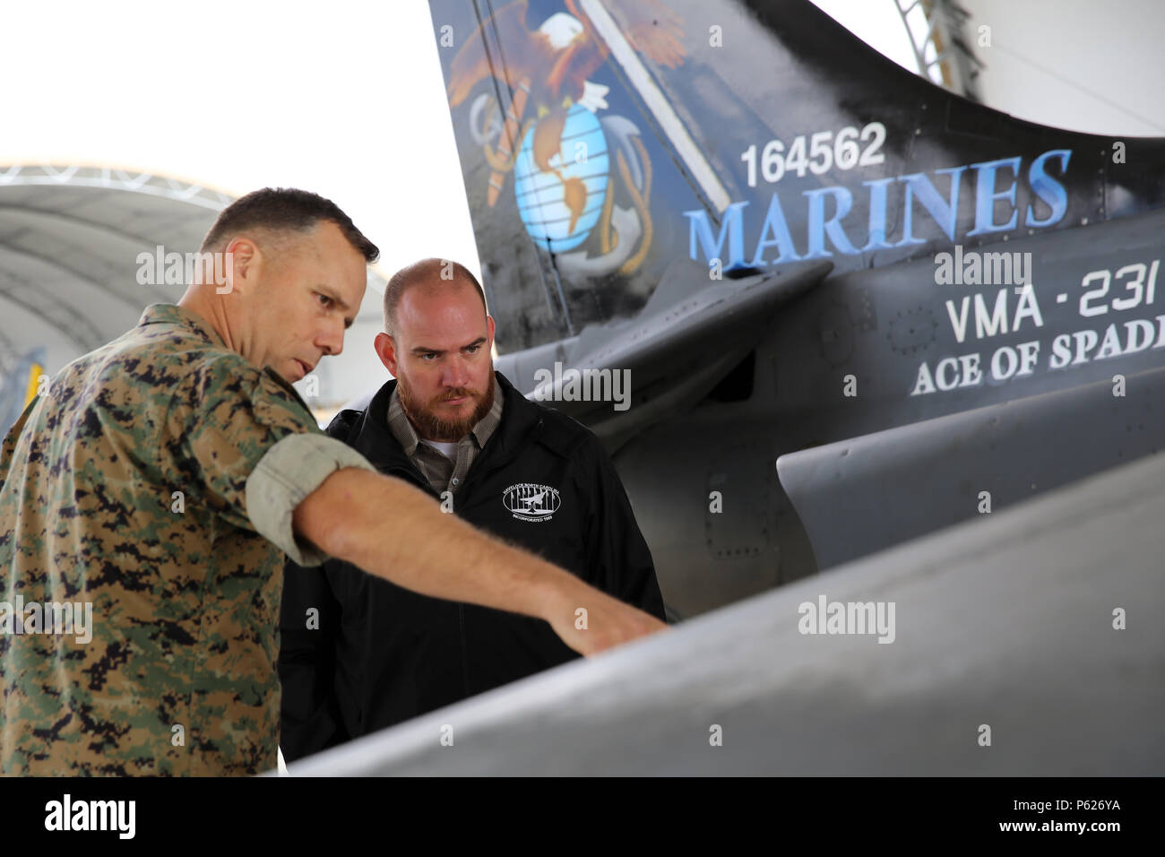Col. Eric Austin, left, points at the wing of an AV-8B Harrier with ...