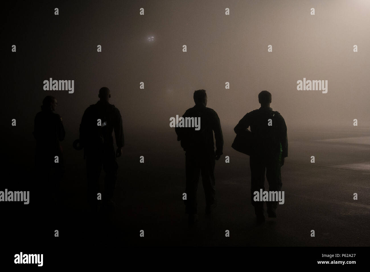 A U.S. Air Force aircrew walks through heavy fog after a mission at ...