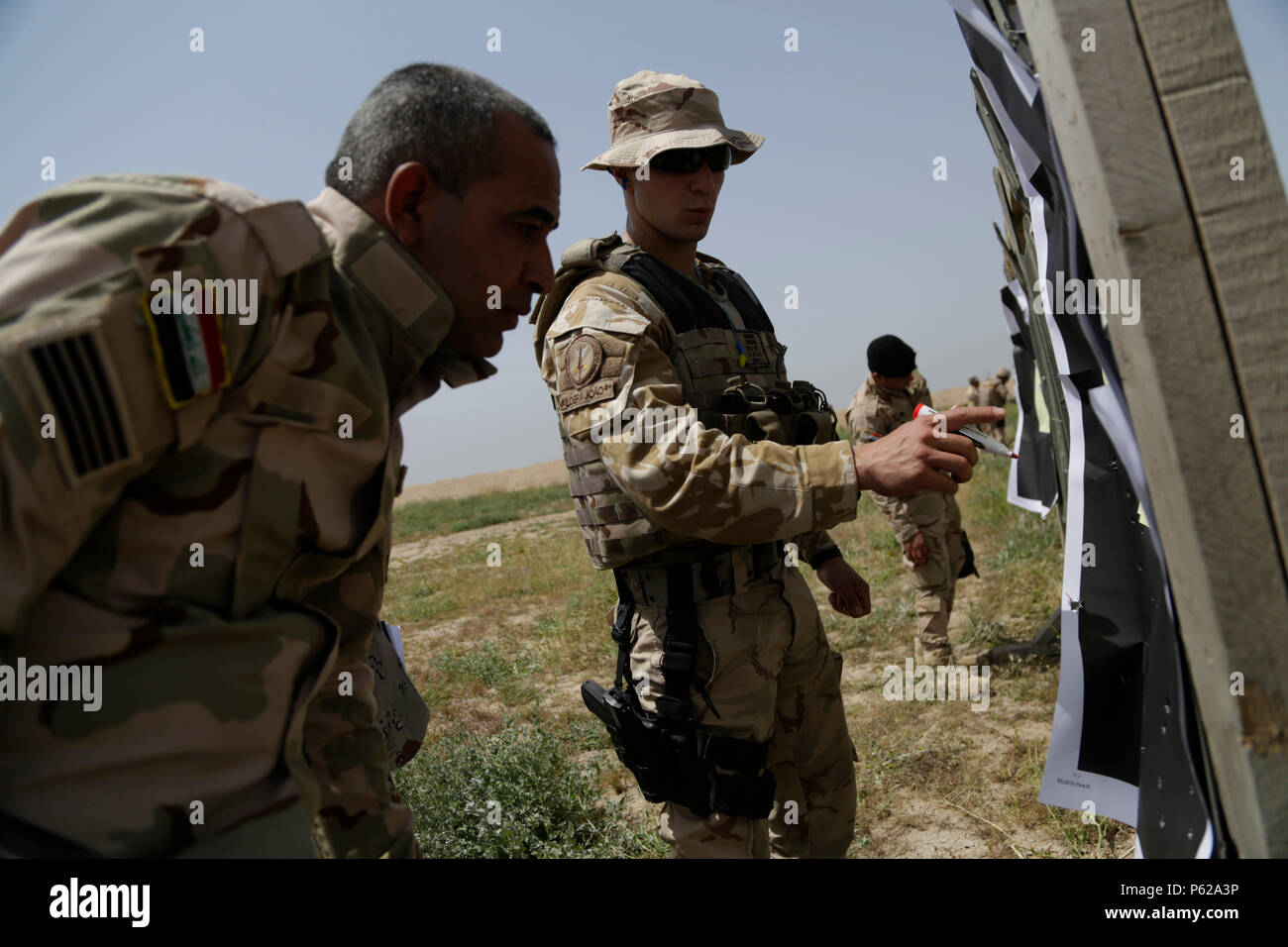 A Portuguese Coalition trainer points out a shot grouping to an Iraqi ...