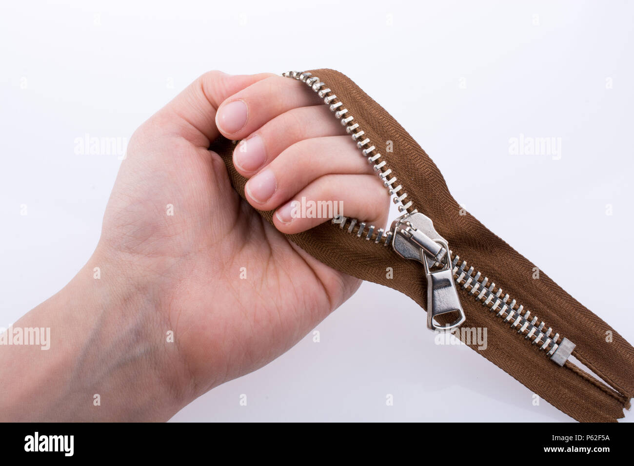 Hand holding color zipper on a white background Stock Photo - Alamy