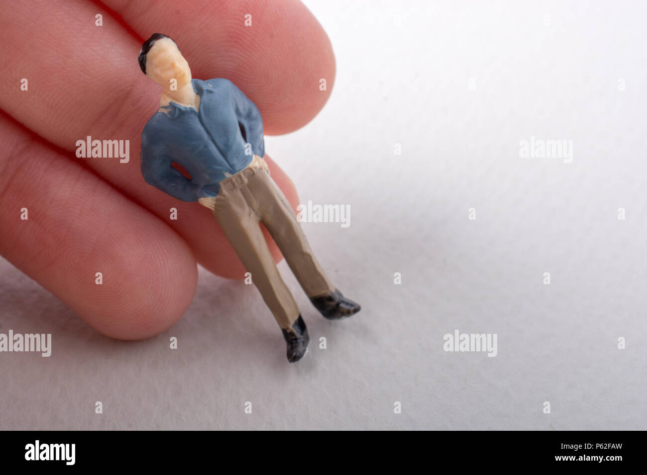 Tiny figurine of man miniature model in hand Stock Photo - Alamy