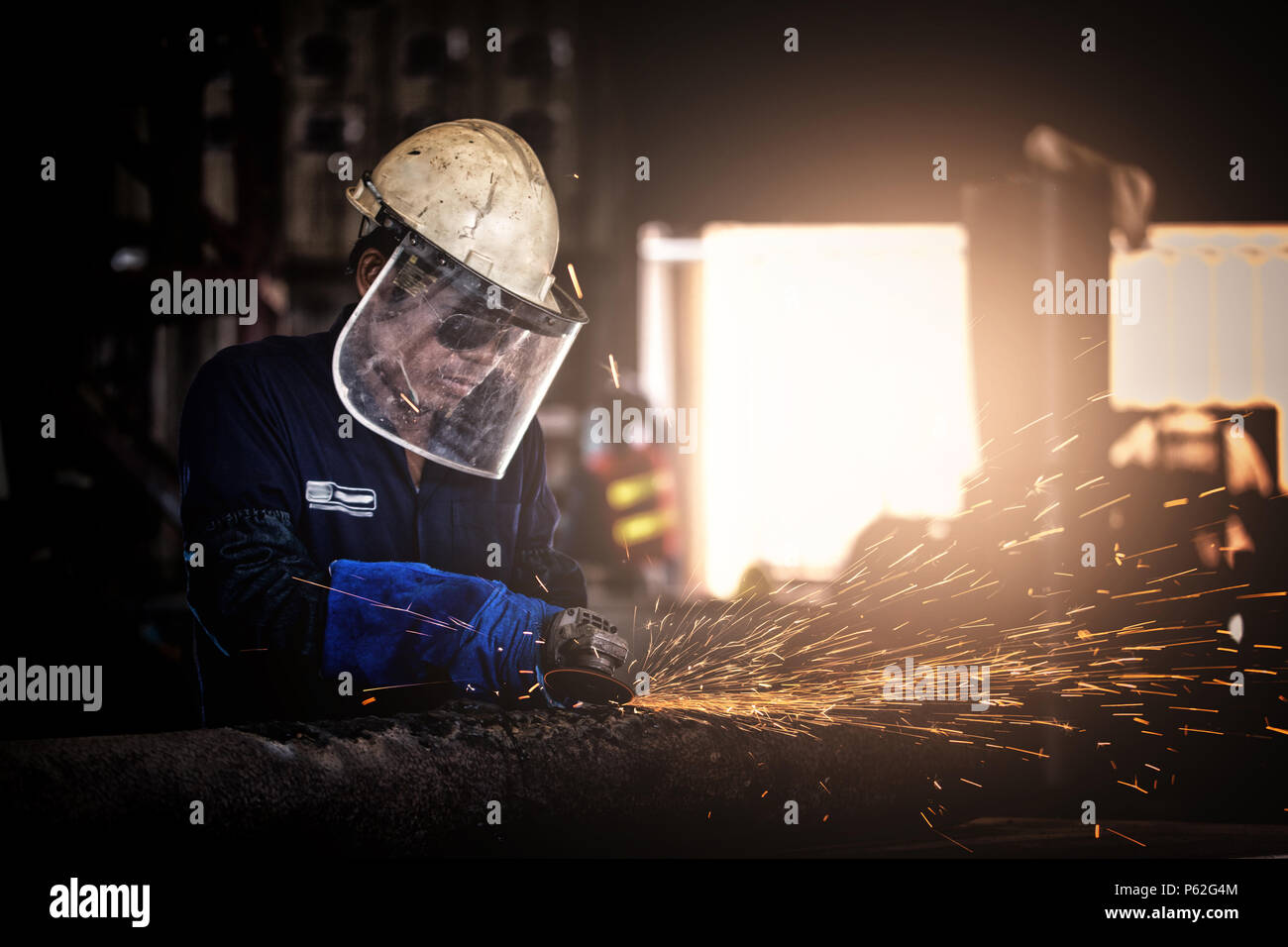 Electric wheel grinding on steel structure in factory.Handyman with ...