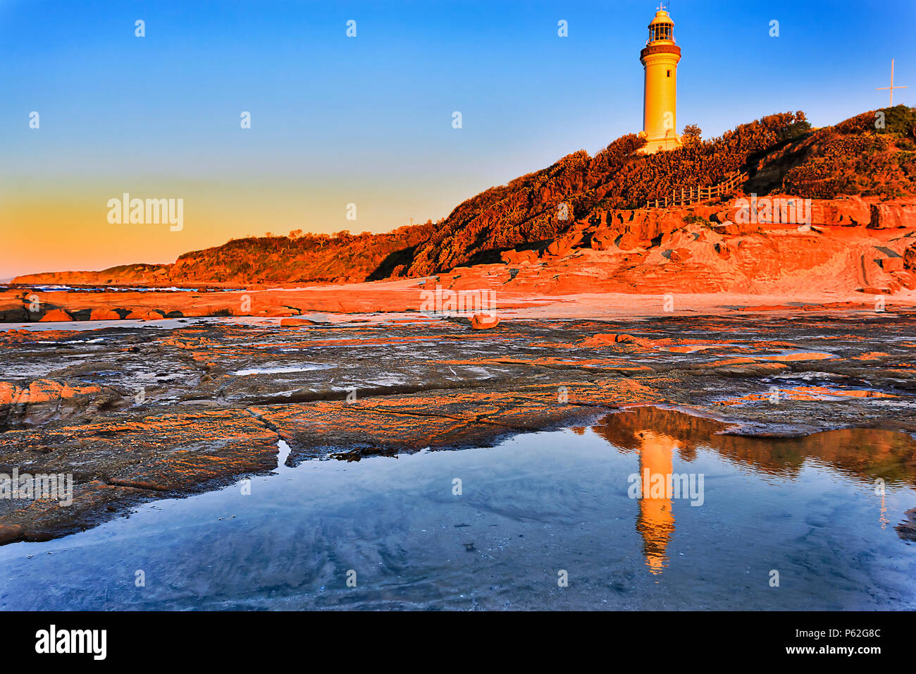 Historic white lighthouse on Norah head in warm morning light ...
