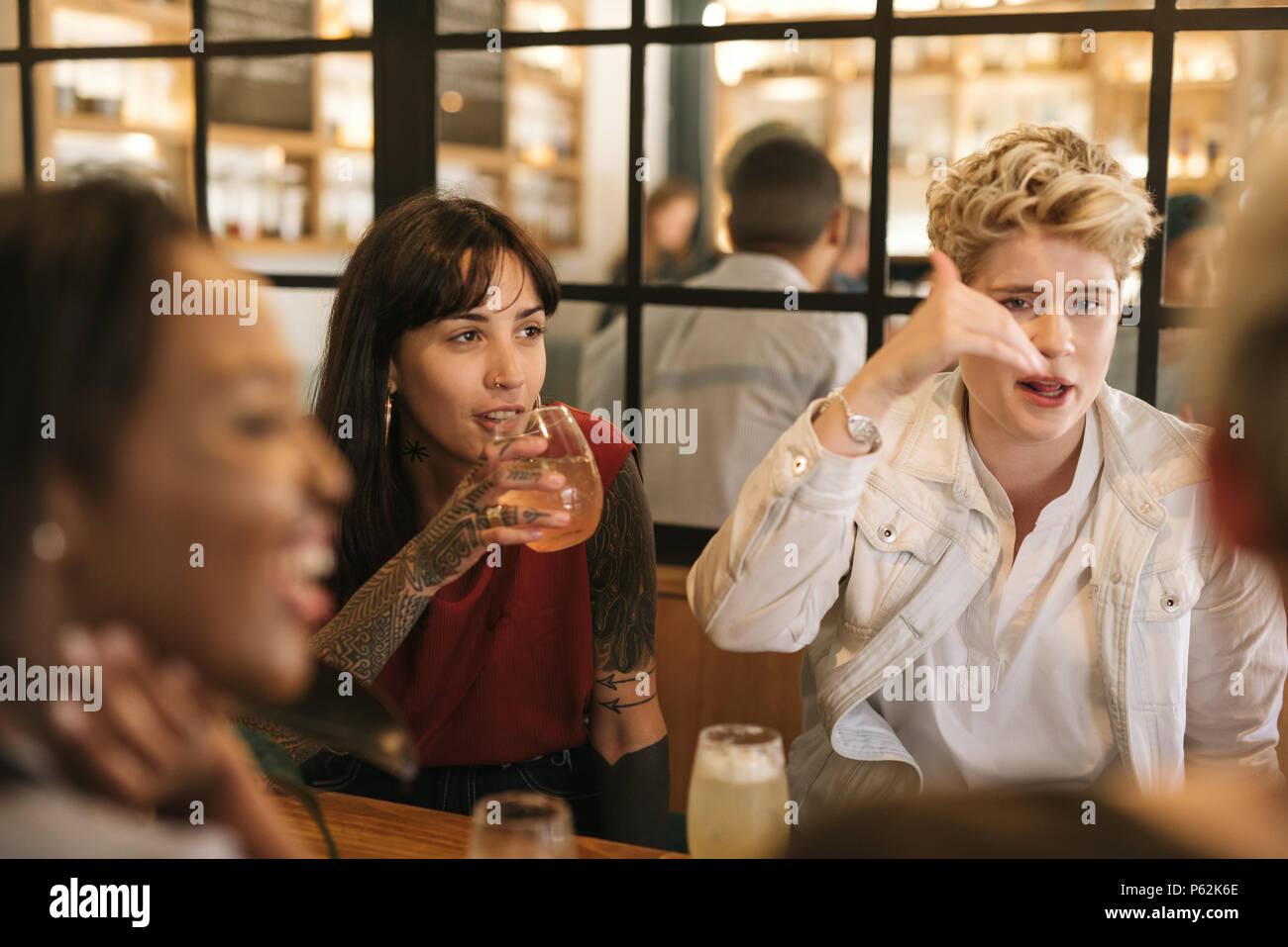 Diverse young girlfriends hanging out together in a trendy bistro Stock ...