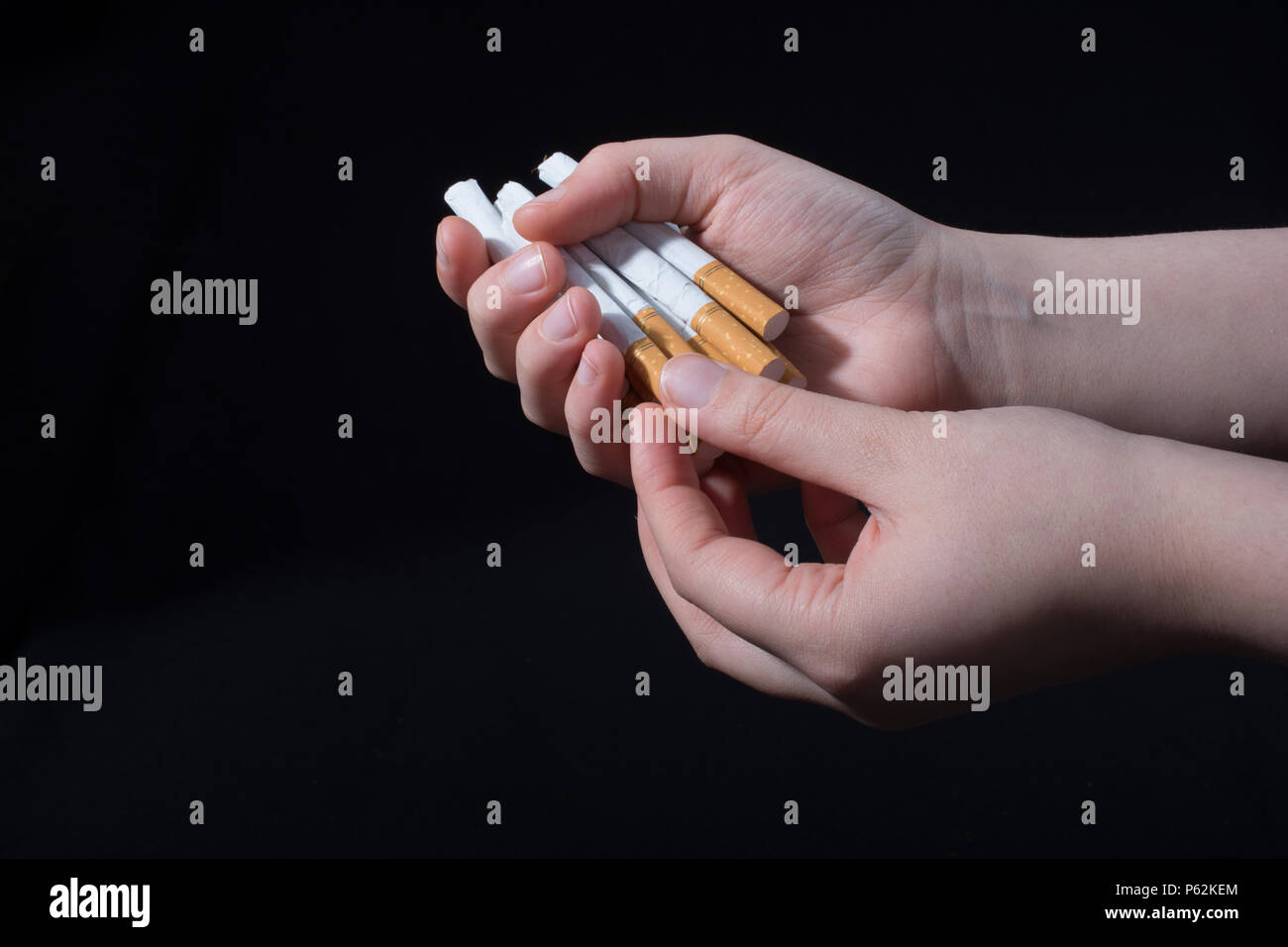 Hand is giving out bundle of cigarettes on black background Stock Photo ...
