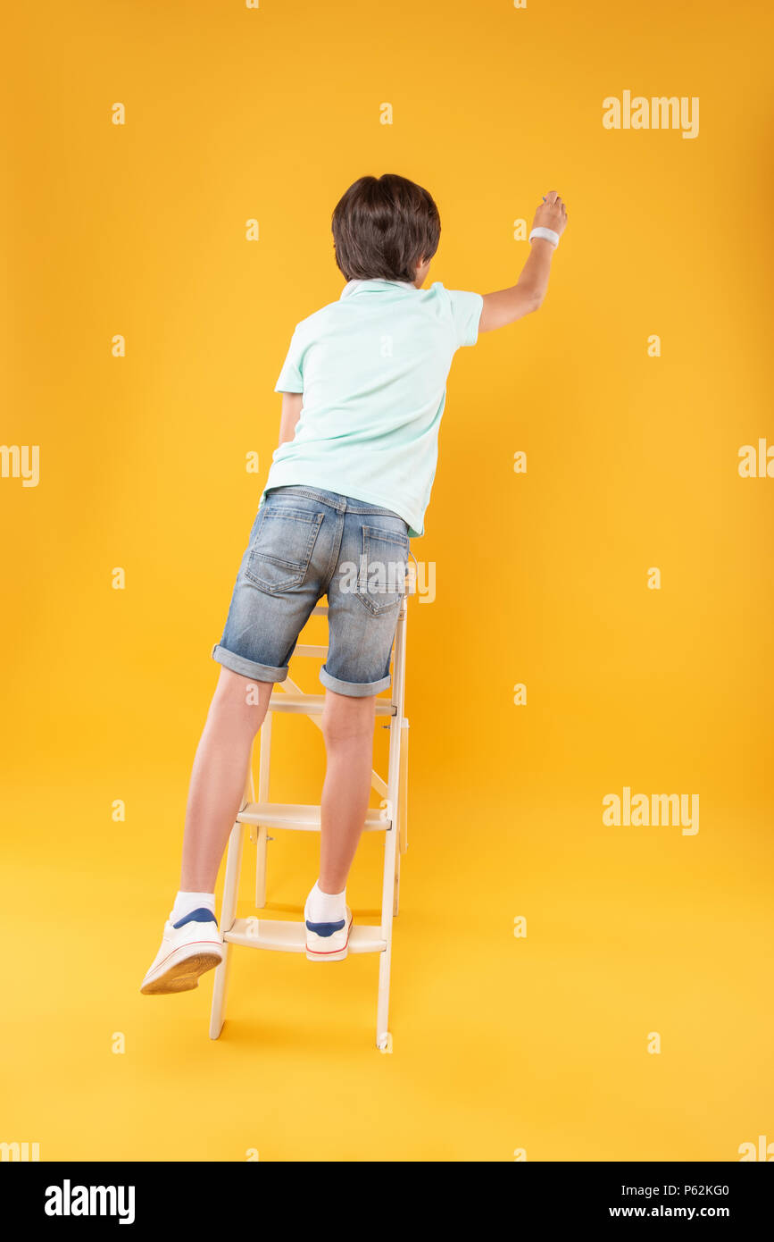 Boy standing on ladder hi-res stock photography and images - Alamy