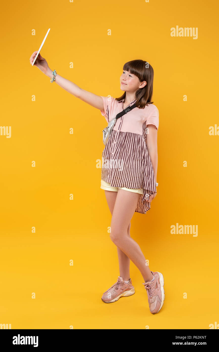 Inspired girl taking photos with her tablet Stock Photo - Alamy