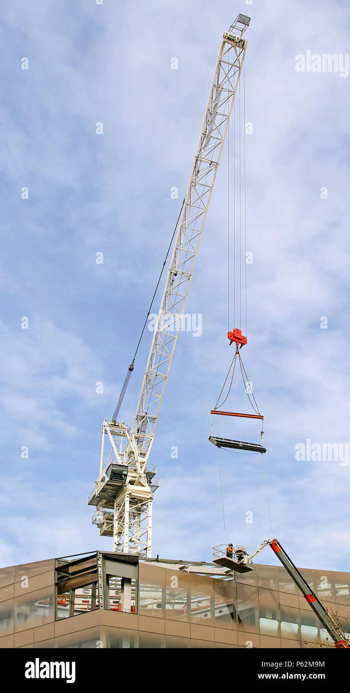 Fitting Big Windows With Crane on a New Building Stock Photo - Alamy