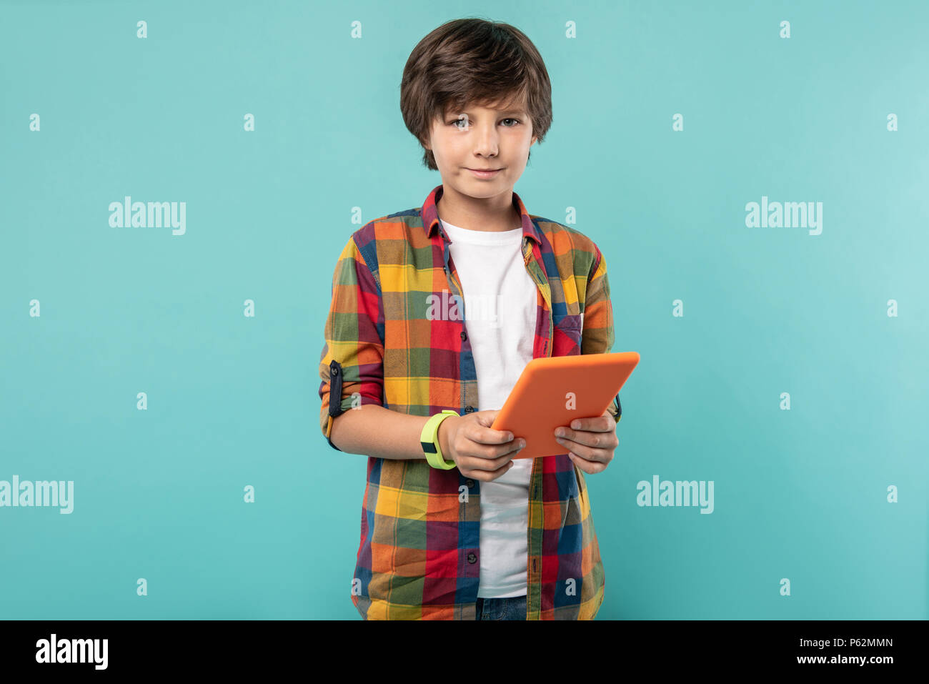 Happy sweet boy holding his tablet Stock Photo - Alamy