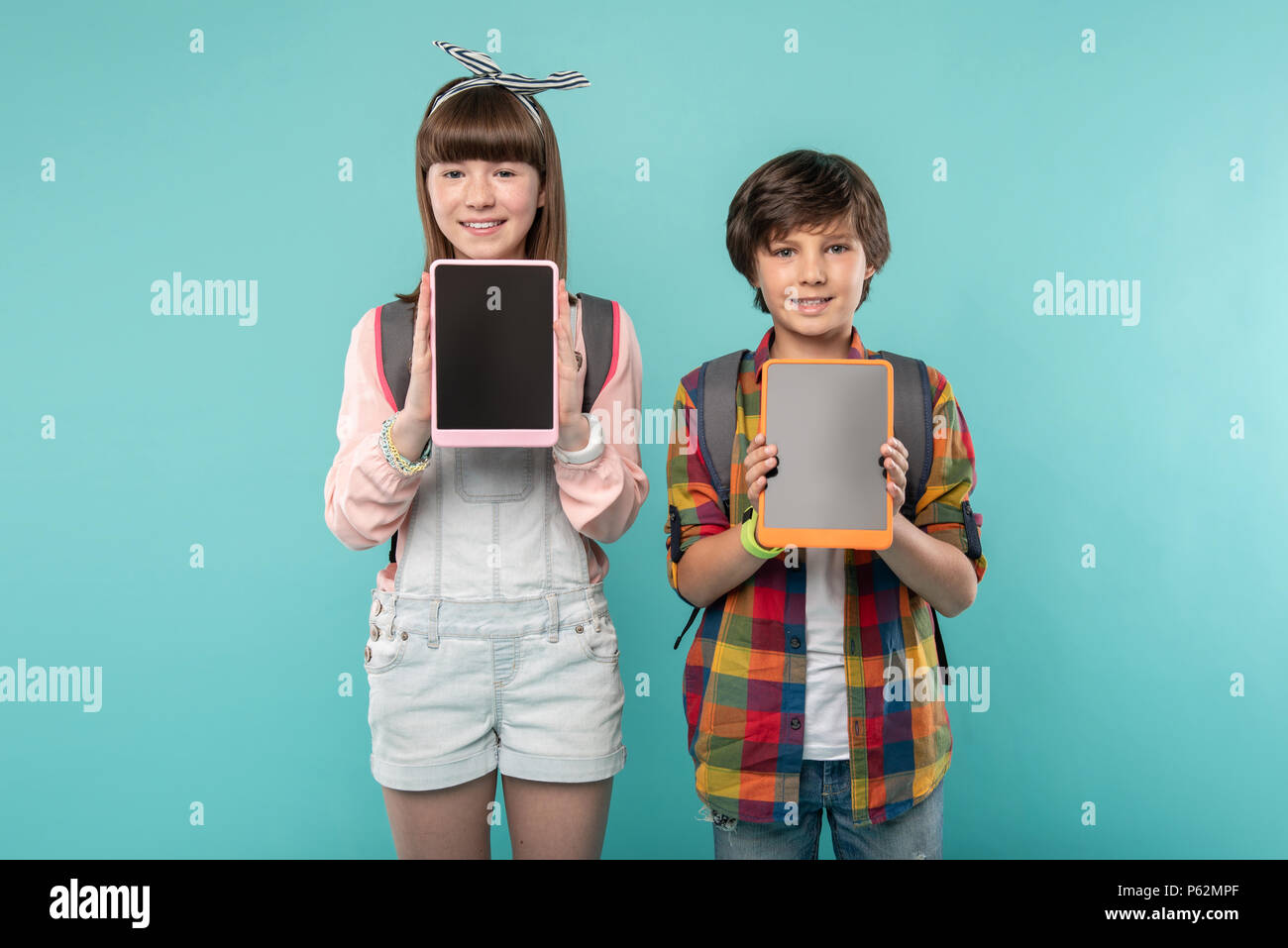 Happy kids showing their tablets Stock Photo - Alamy