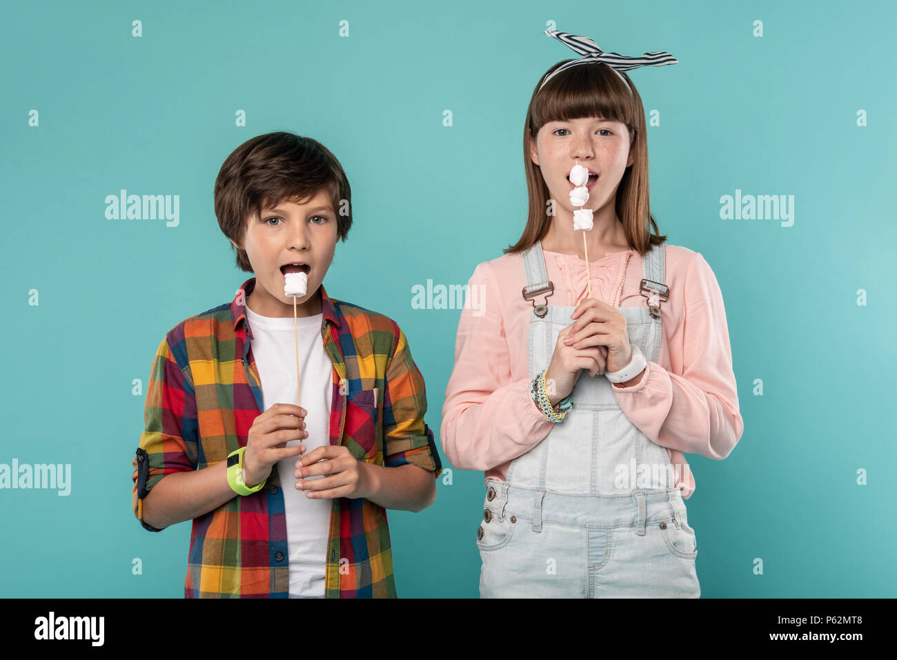 Happy kids eating delicious cookies Stock Photo - Alamy