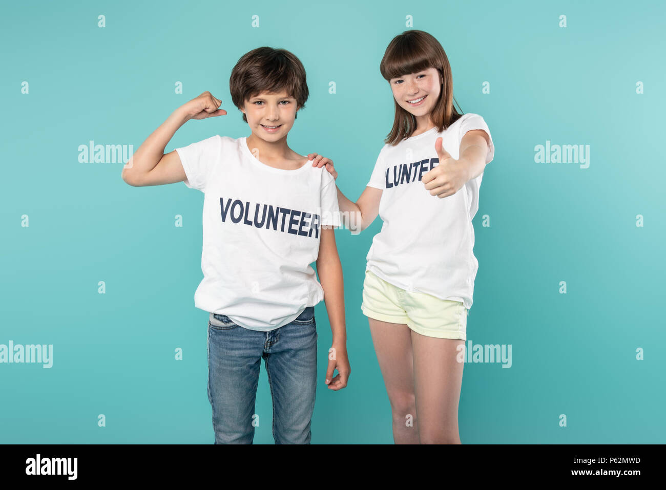 Cheerful volunteers showing their muscles Stock Photo - Alamy