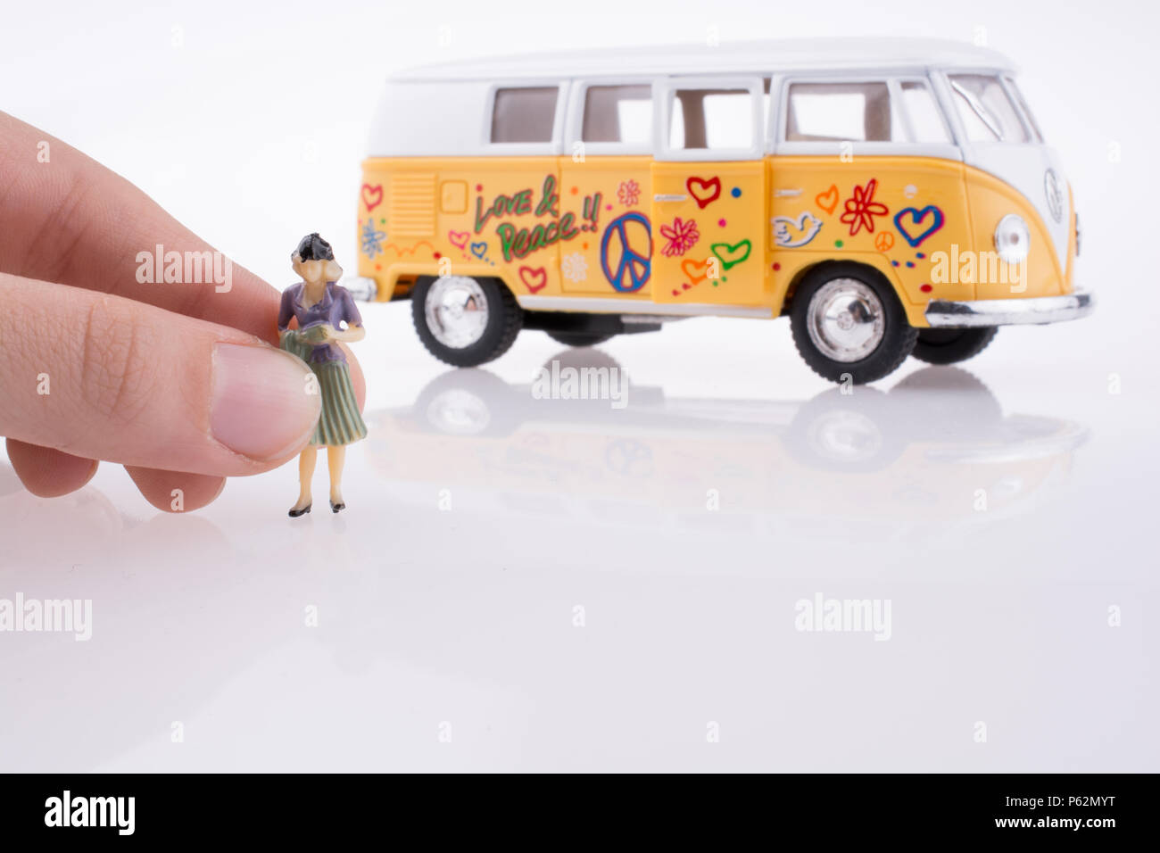 Hand holding a human figure near a peace van on a white background ...